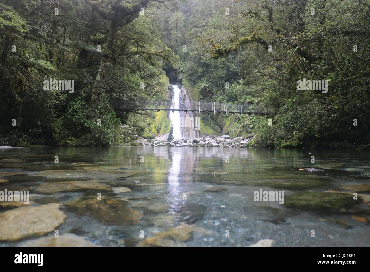 A swing bridge with Giants gate waterfall in the background, Milford ...