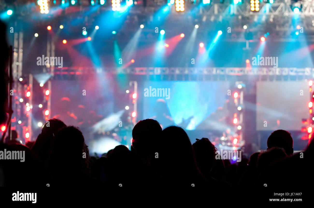 Cheering crowd in front of bright colorful stage lights Stock Photo - Alamy