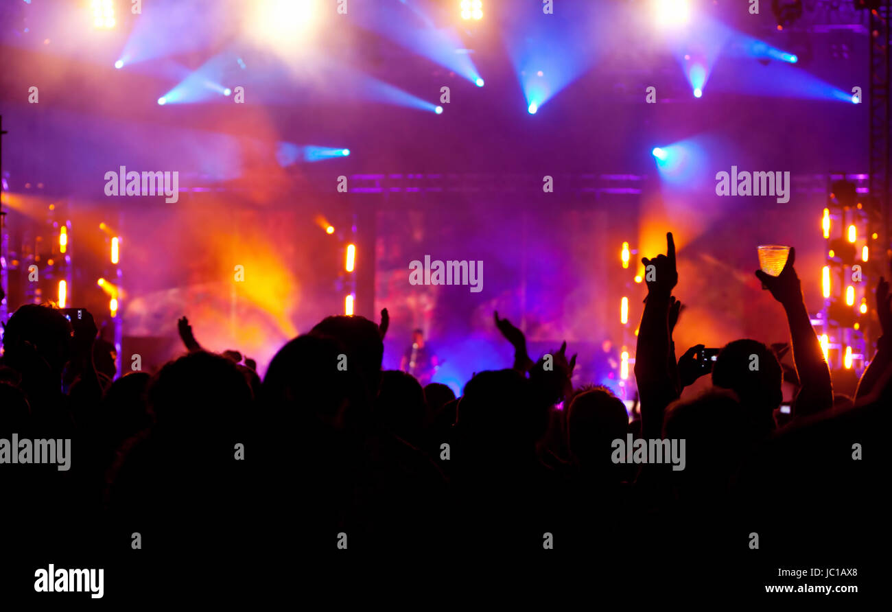 Cheering crowd in front of bright colorful stage lights Stock Photo - Alamy