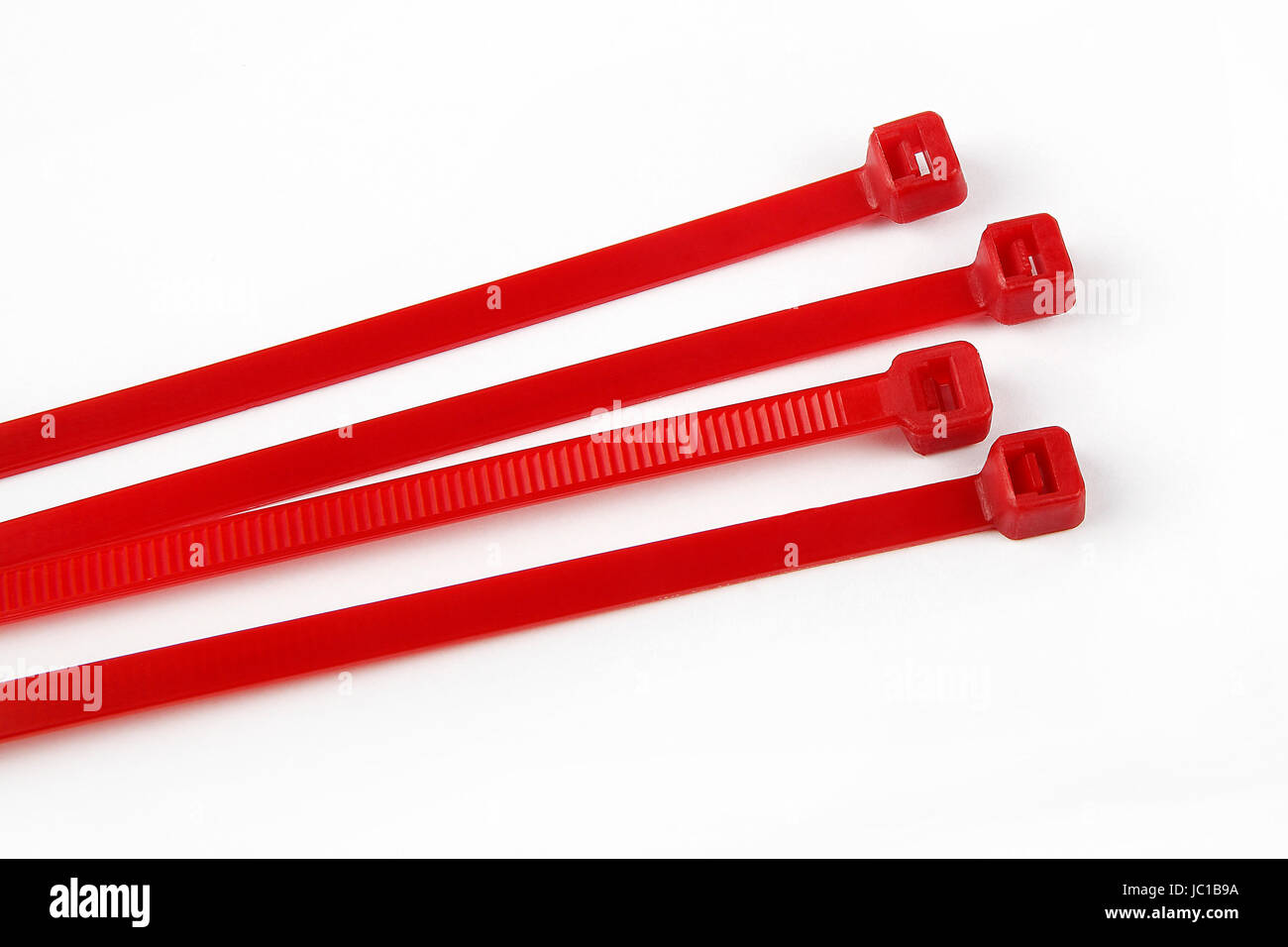 Cable ties in red in front of white background Stock Photo - Alamy