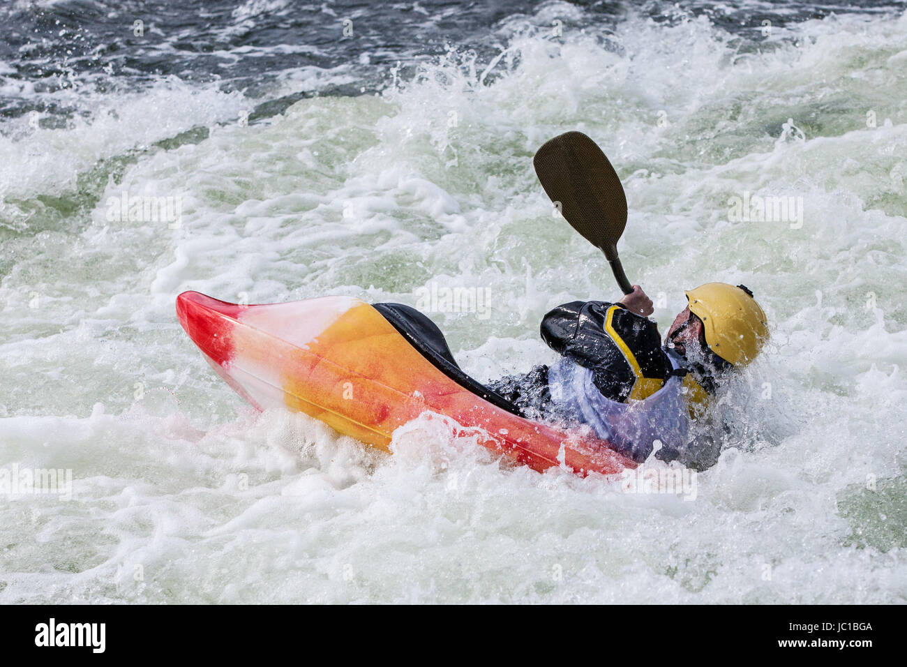 an active male kayaker rolling and surfing in rough water Stock Photo ...