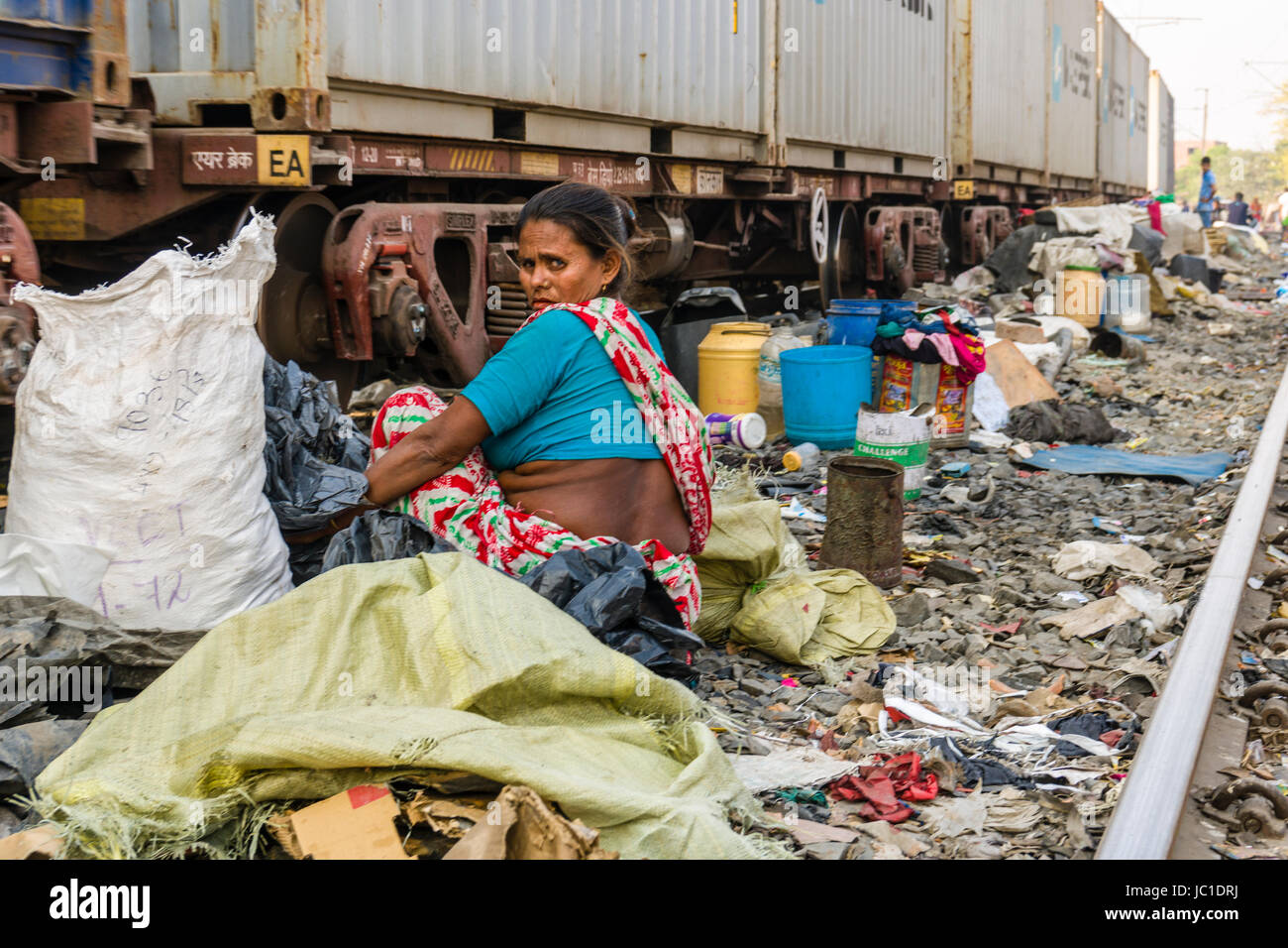 A woman is sorting out garbage between the railroad tracks in Park ...