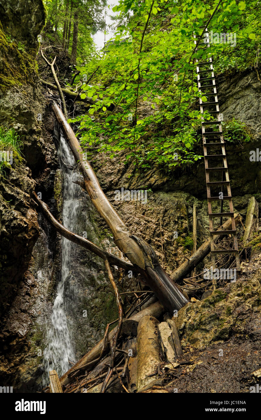 Picturesque view of waterfall between two mountain walls with a wooden ...