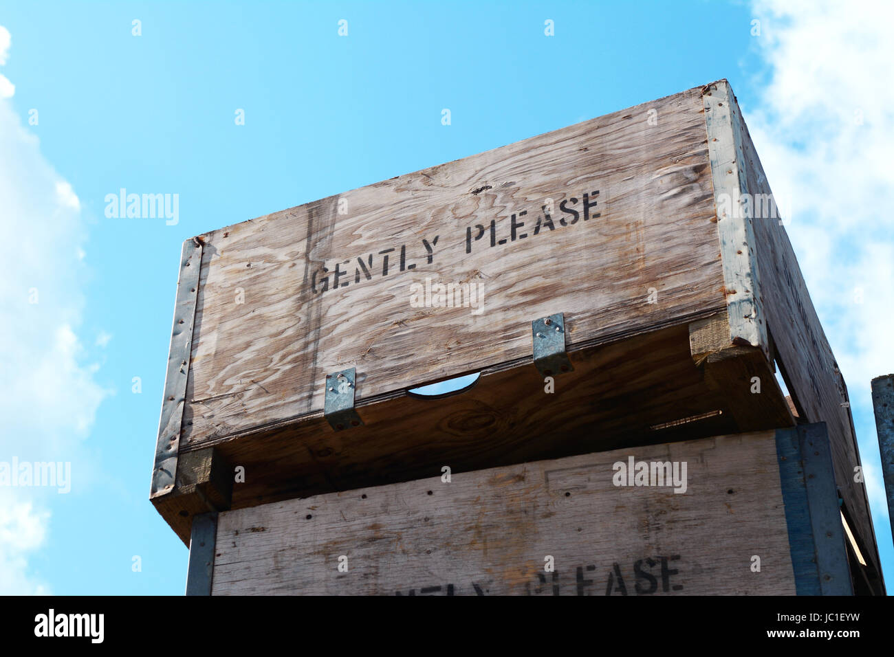 Wooden fruit boxes stacked high against a blue sky, labelled with the ...