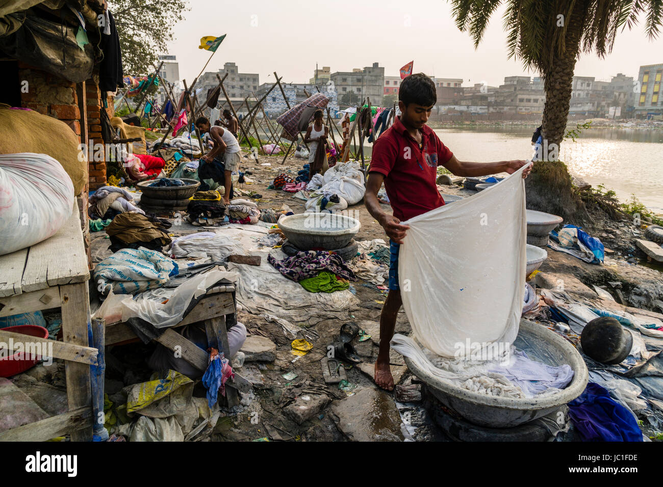 A man, dhobi, is doing laundry at a lake in the suburb Topsia Stock ...
