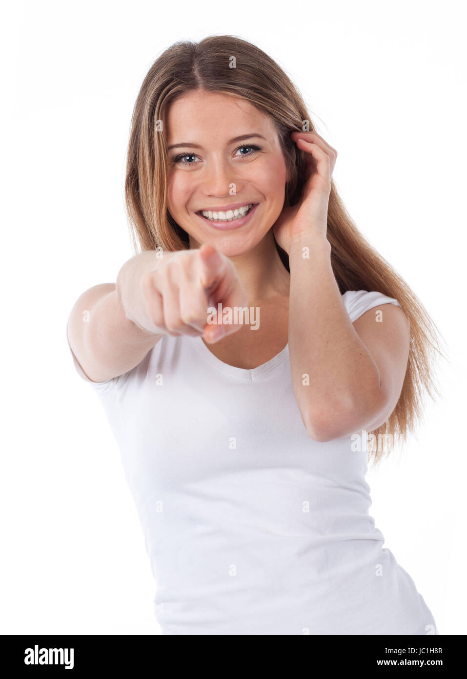 Portrait of a smiling woman pointing in front of her, isolated on white ...