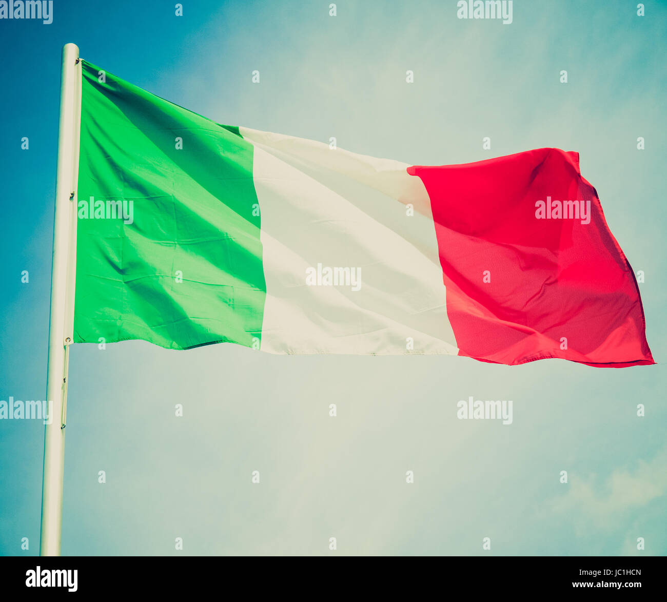 Vintage retro looking Flag of Italy over a blue sky Stock Photo - Alamy