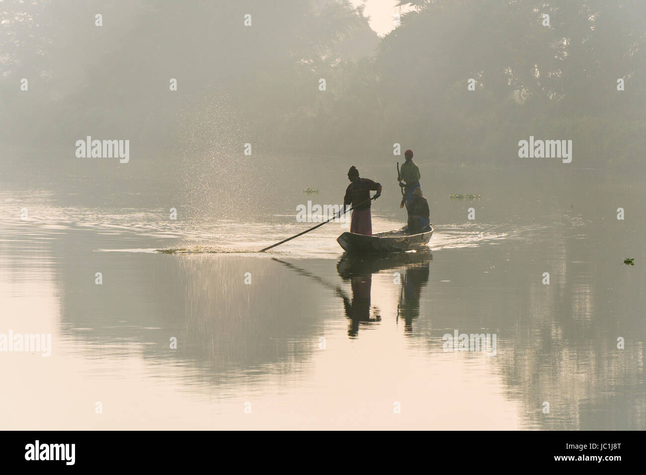 Fishermen driving boats on the foggy fish breeding lakes in the rural ...