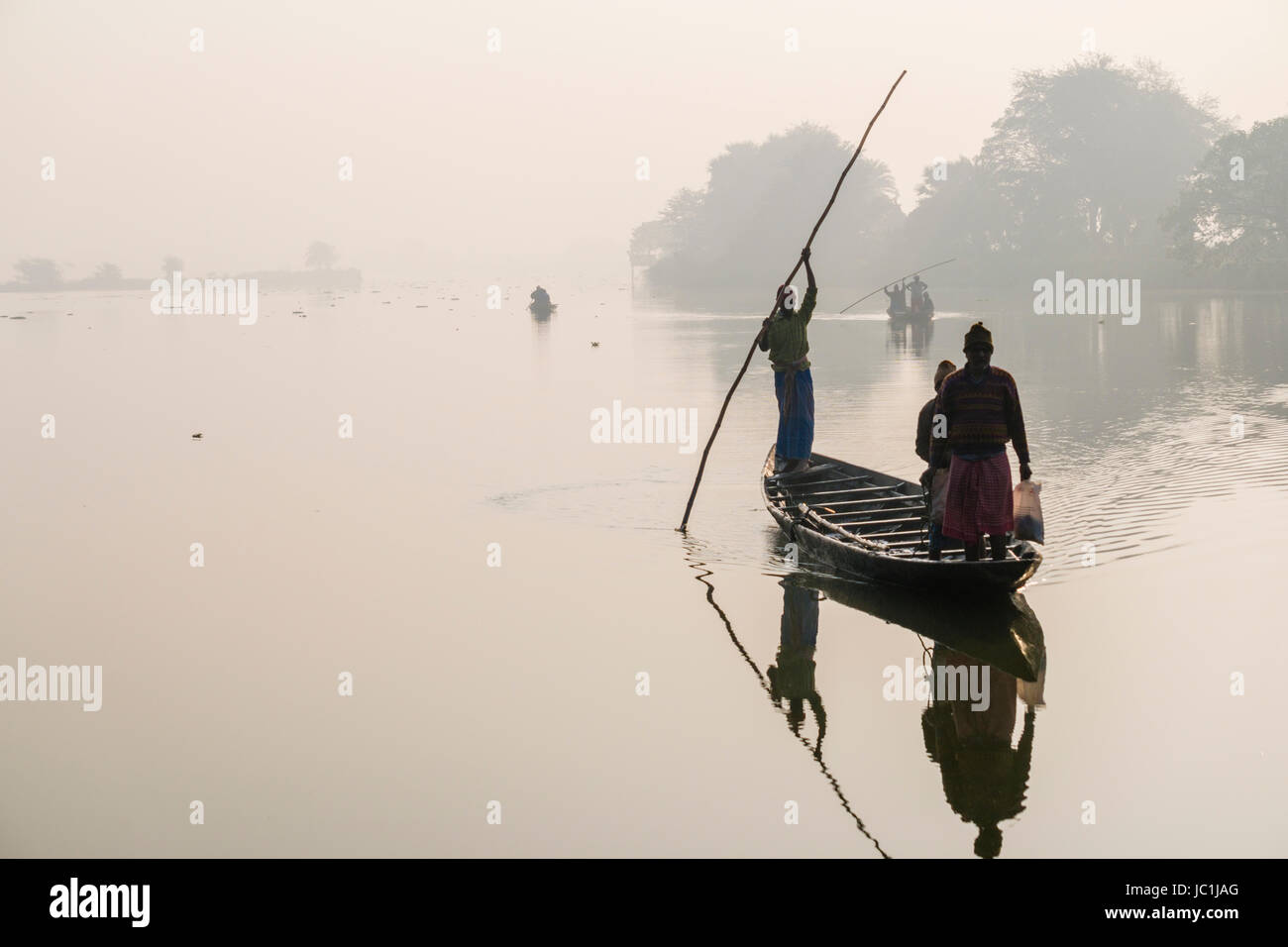 Fishermen driving boats on the foggy fish breeding lakes in the rural ...