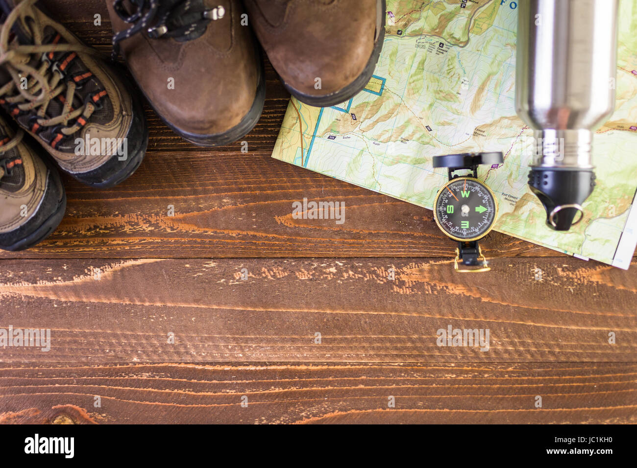 Hiking shoes with topo map and compass on a wood background Stock Photo ...