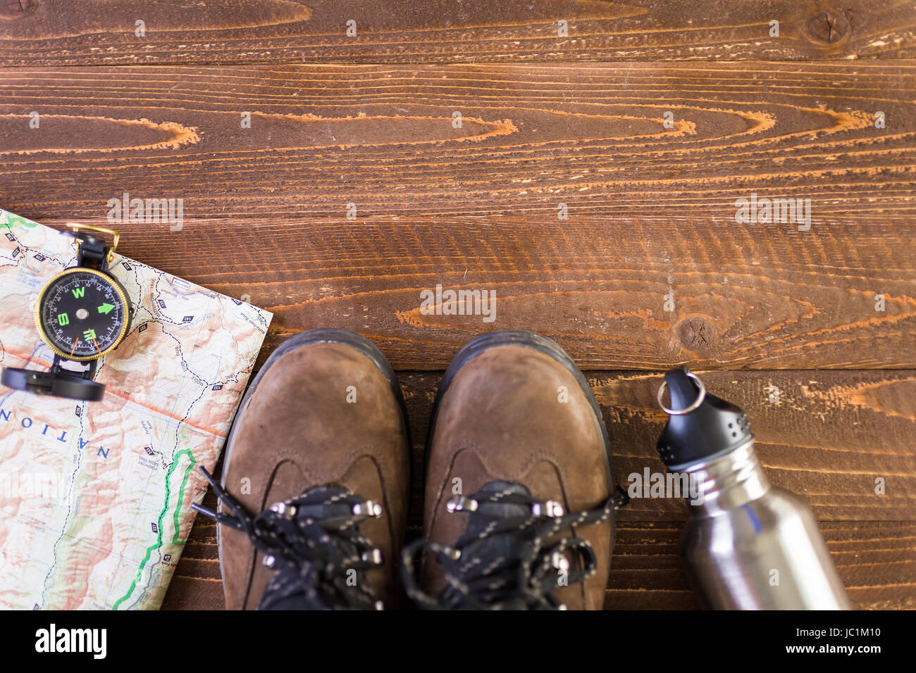 Hiking shoes with topo map and compass on a wood background Stock Photo ...