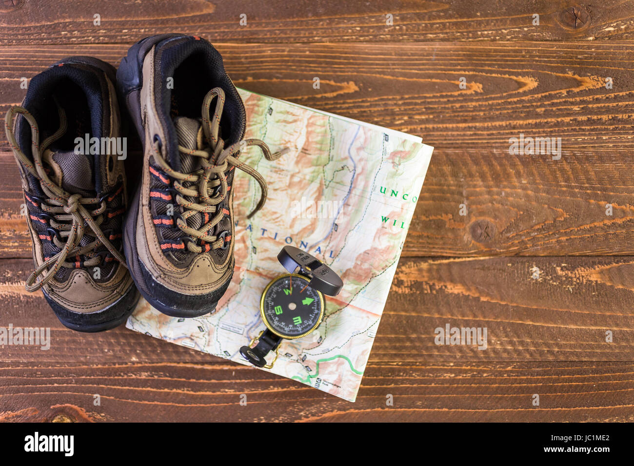 Hiking shoes with topo map and compass on a wood background Stock Photo ...