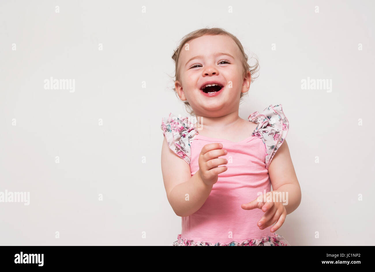 Cute happy baby is laughing fearless and freely with her new teeth ...