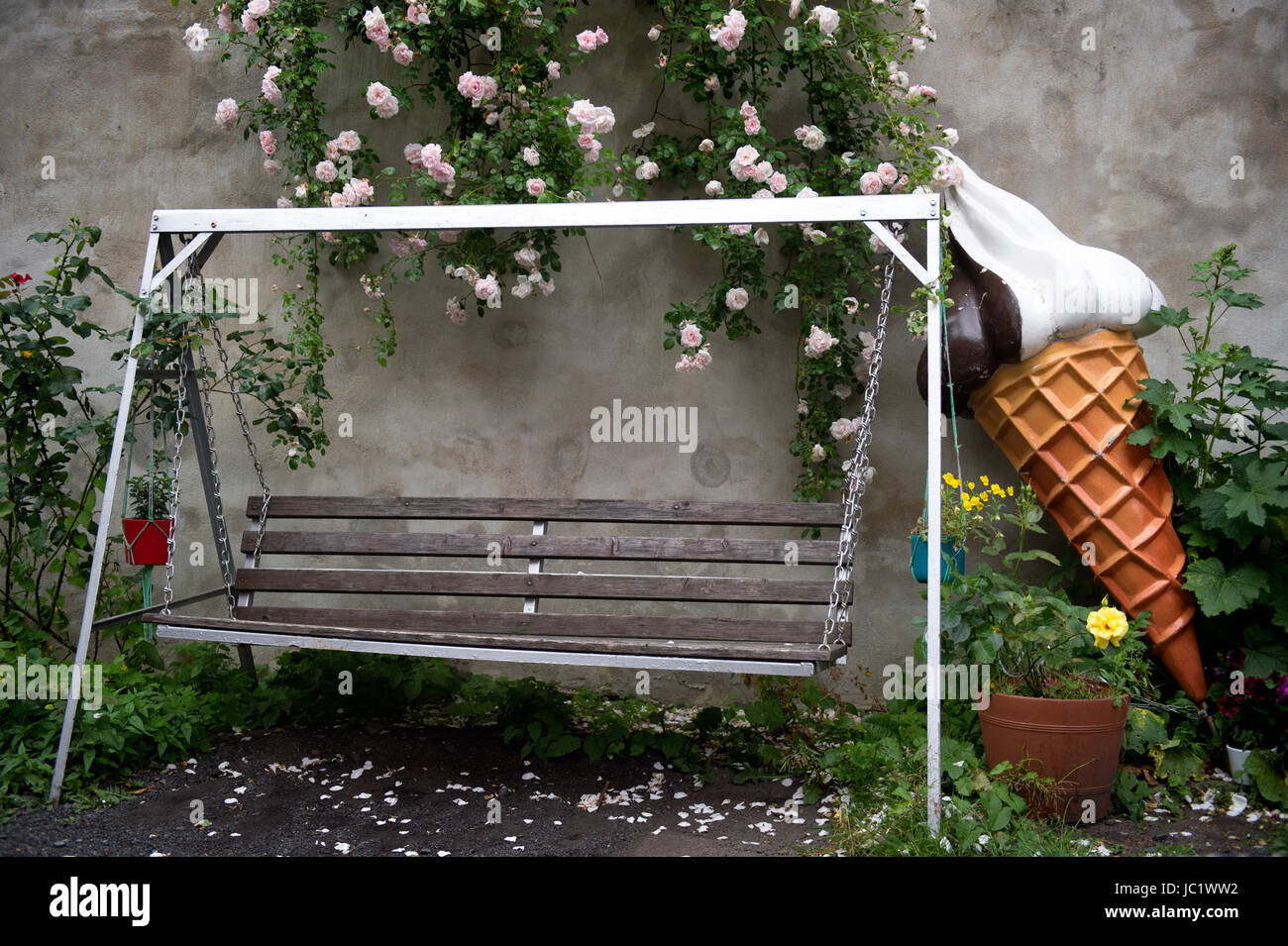 A giant plastic ice cream cone can be seen next ot a Hollywood swing in ...