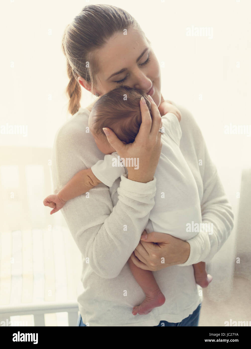 Toned portrait of smiling caring mother holding cute baby boy on hands Stock Photo - Alamy