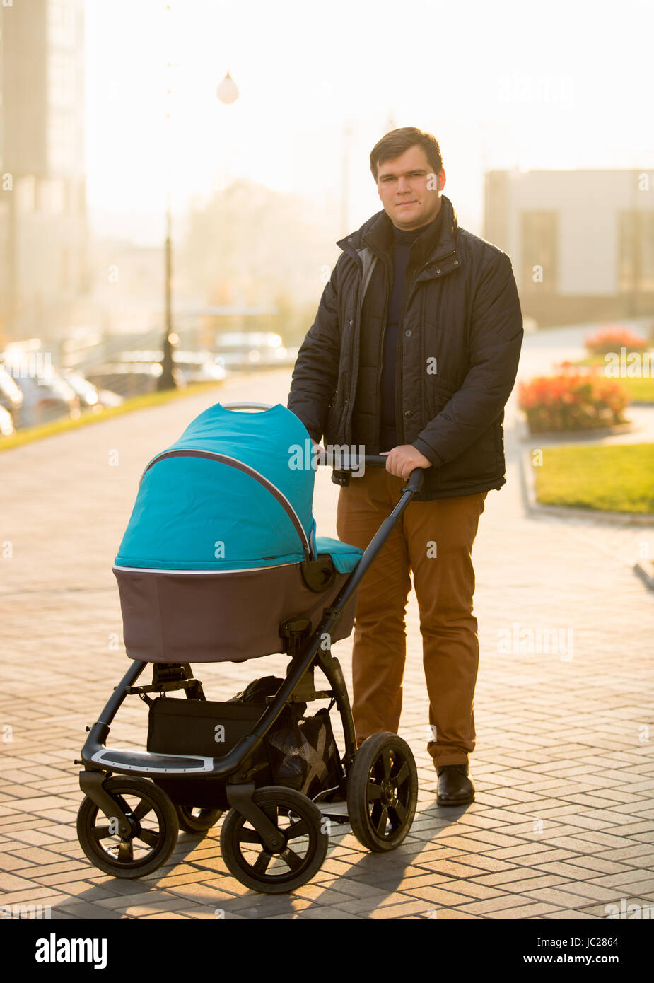 Handsome young man walking with the pram on street Stock Photo - Alamy