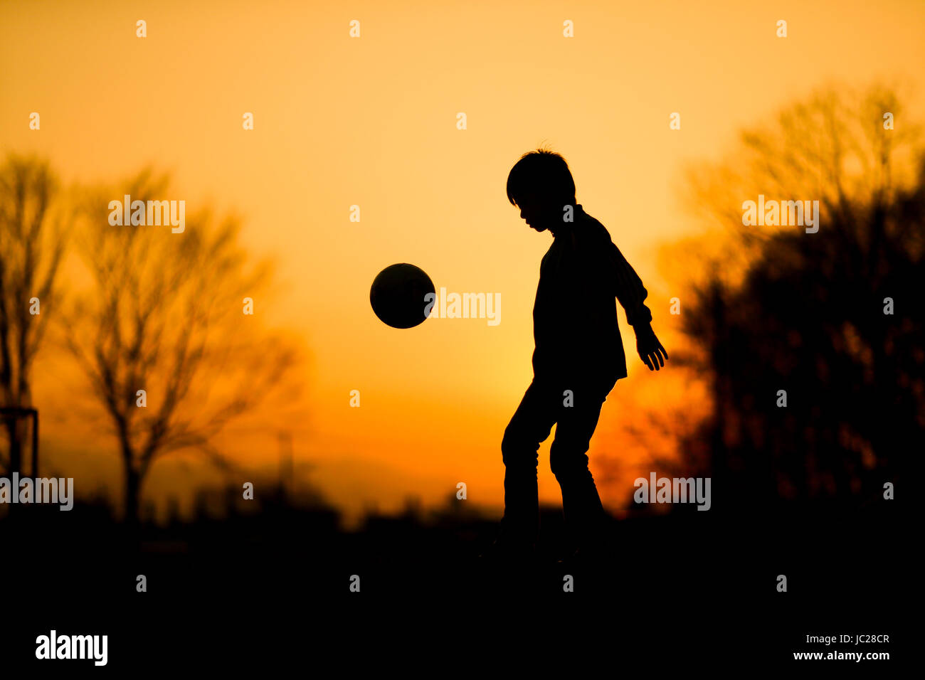 Boy Lifting Ball Stock Photo - Alamy