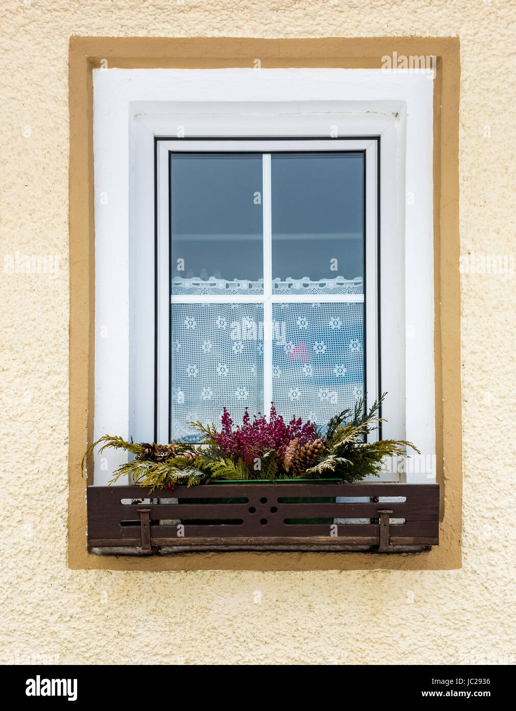 Beautiful flowers growing under window in traditional Austrian house ...
