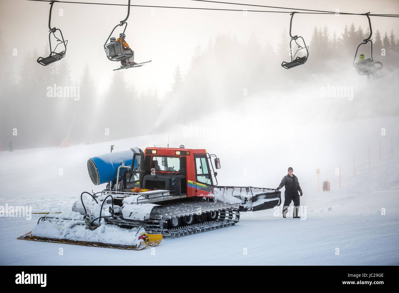 Big snow cleaning machine working on ski slope under cable chairs Stock ...