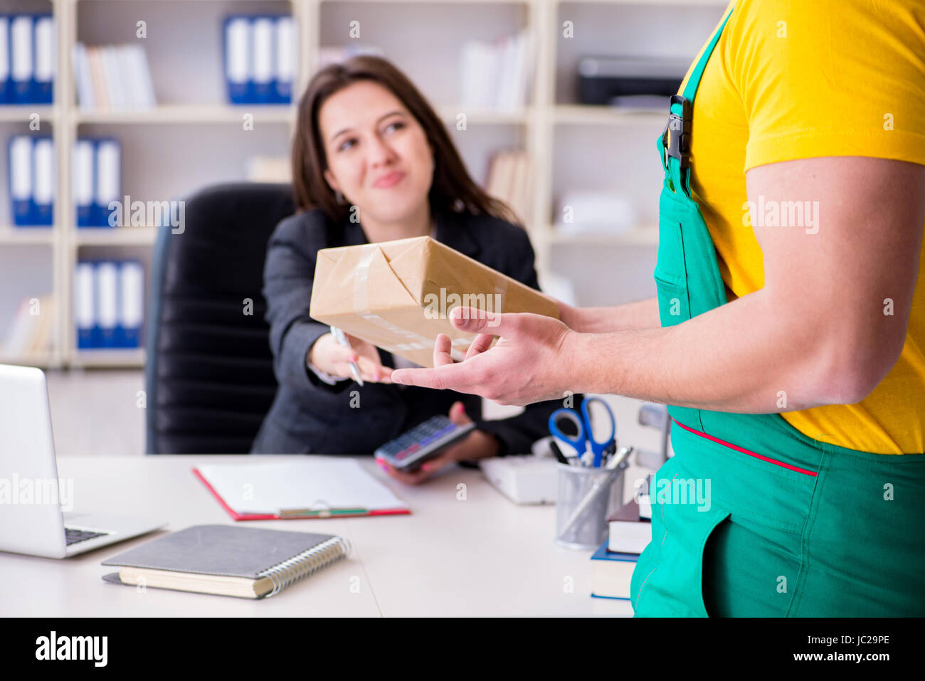 Postman delivering parcel to the office Stock Photo - Alamy