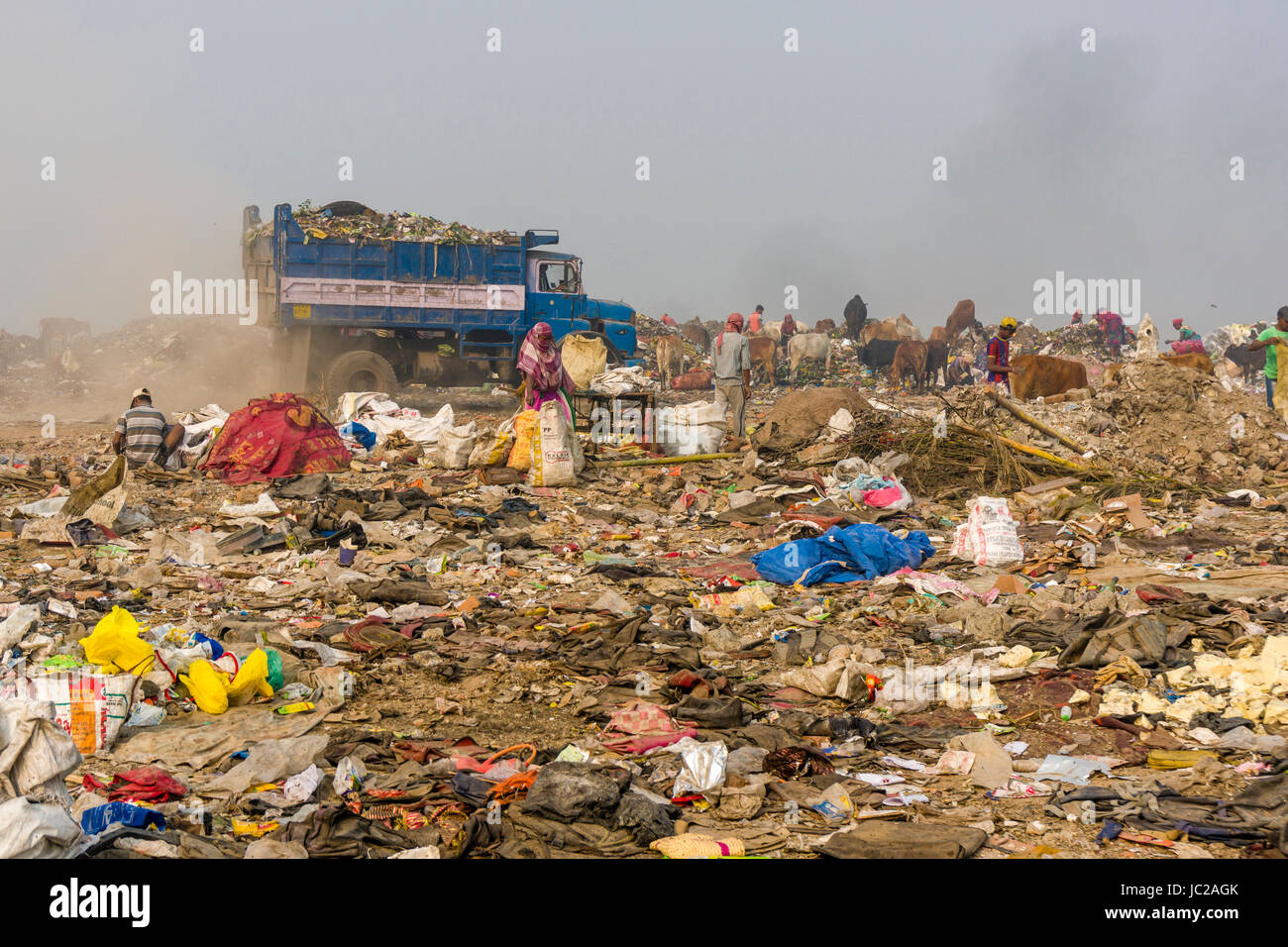 A truck loaded with garbage is driving on top of dusty Dhapa Garbage ...