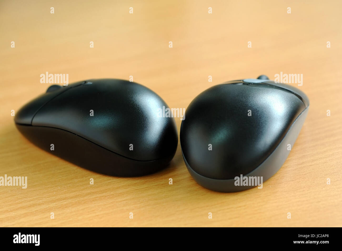 Two black computer wireless mices on desk Stock Photo - Alamy