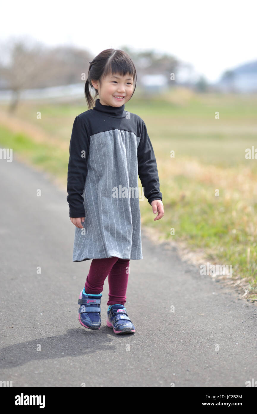 Girl Walking across Road Stock Photo - Alamy