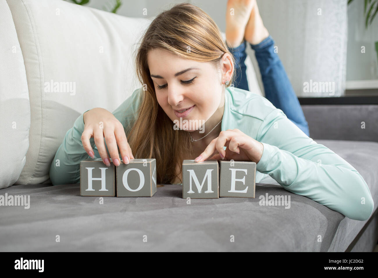 Portrait of cute woman making word "Home" from letters on bricks Stock ...