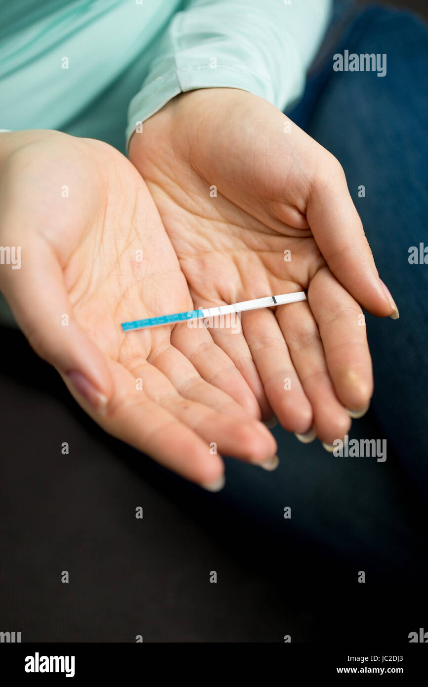 Young woman holding positive pregnancy test in hands Stock Photo - Alamy
