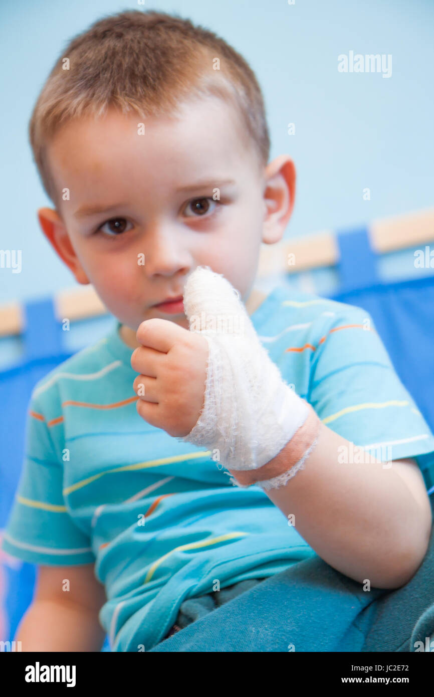 wounded in the left hand with bandage boy at shot in home Stock Photo ...