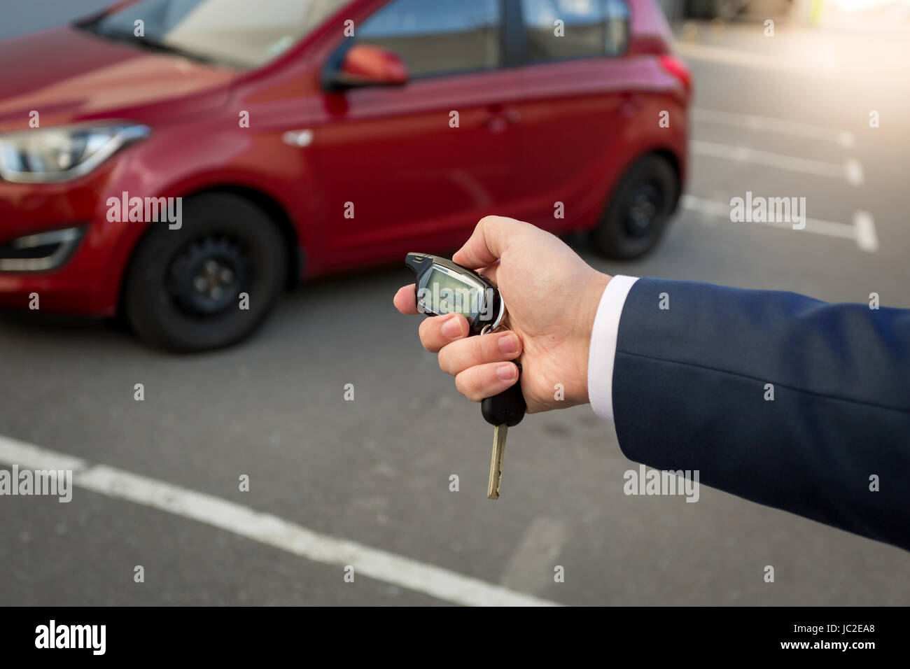 Closeup photo of man pressing the button on remote car alarm system ...
