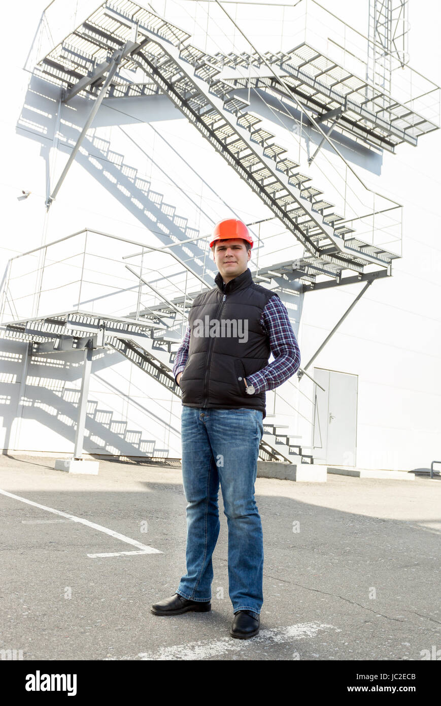 Confident male worker posing against big factory Stock Photo - Alamy