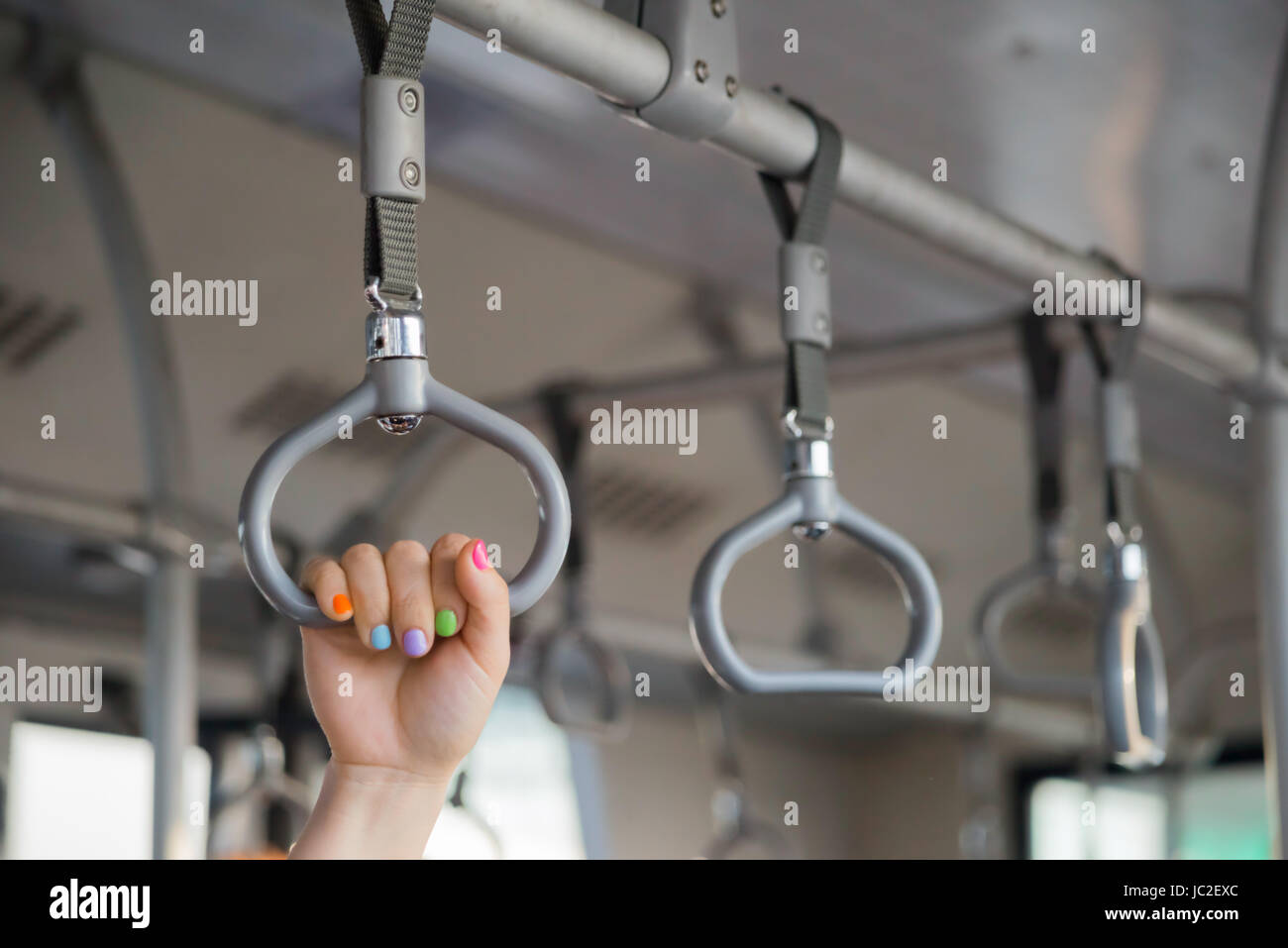 People holding onto a handle on a train Stock Photo - Alamy