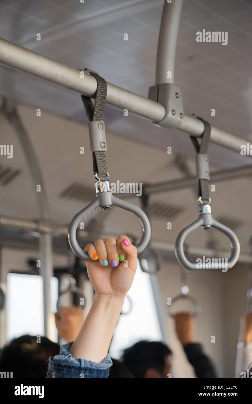 People holding onto a handle on a train Stock Photo - Alamy