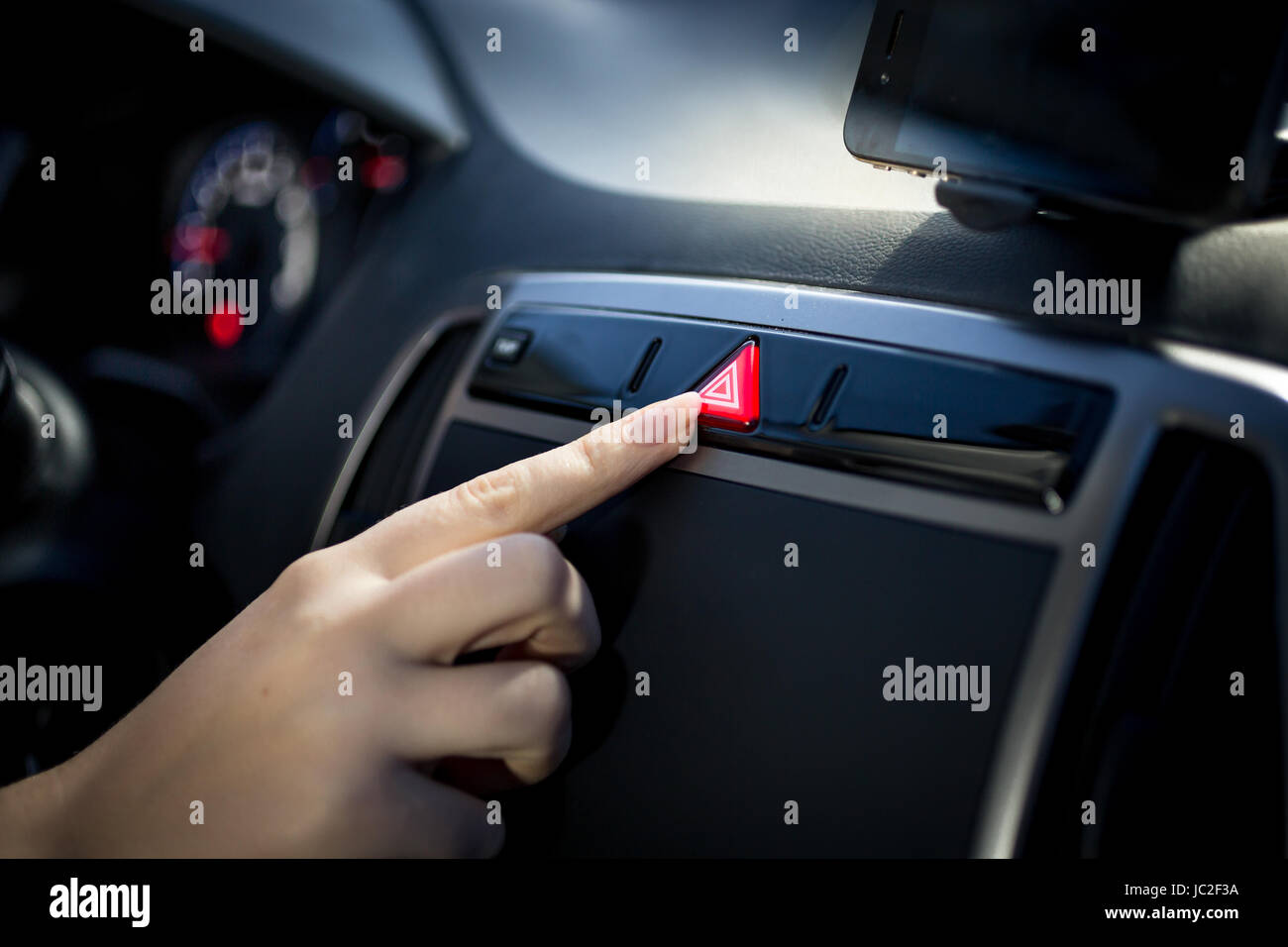 Young woman pressing emergency button on car dashboard Stock Photo - Alamy