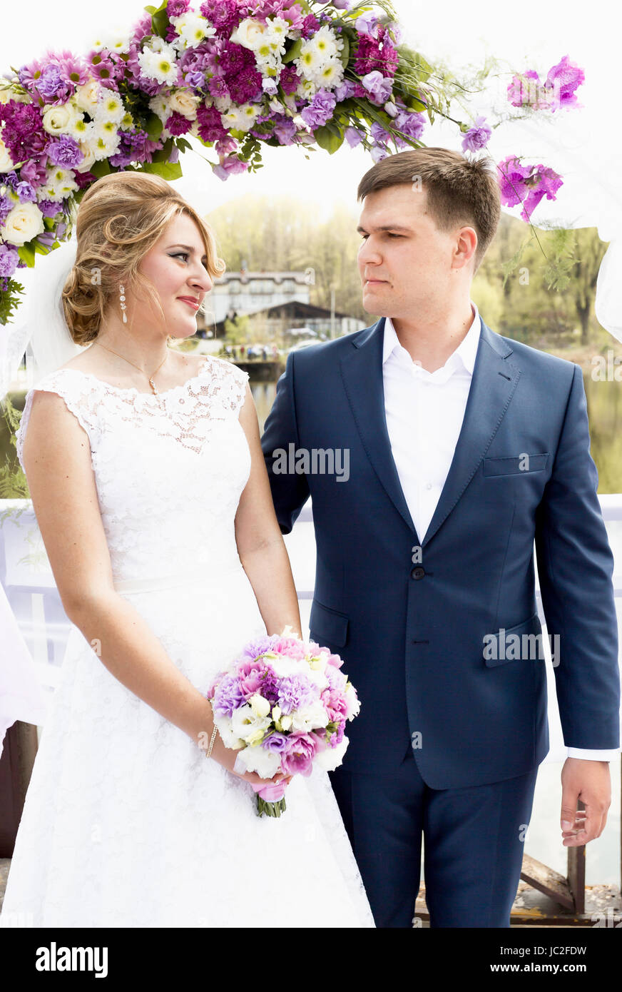 Portrait of cute bride and groom looking at each other at wedding ...