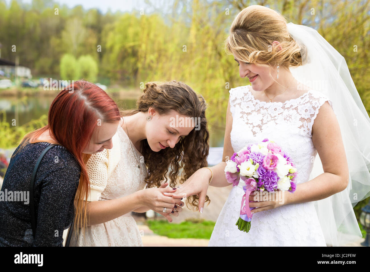 Portrait of happy bride showing wedding ring to bridesmaids Stock Photo ...