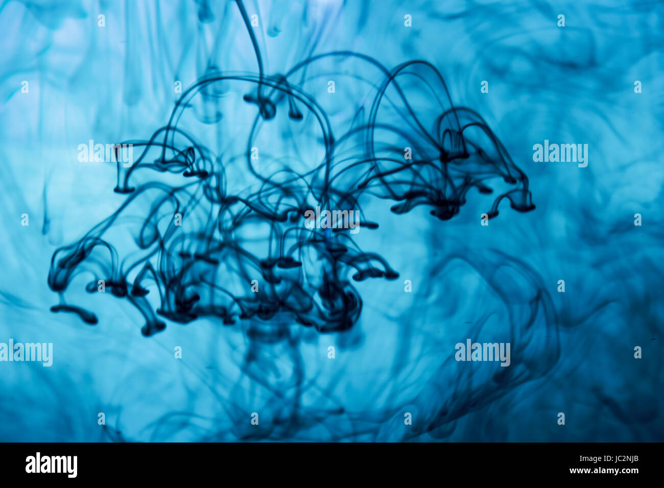 Vegetable ink poured into water with white background Stock Photo - Alamy