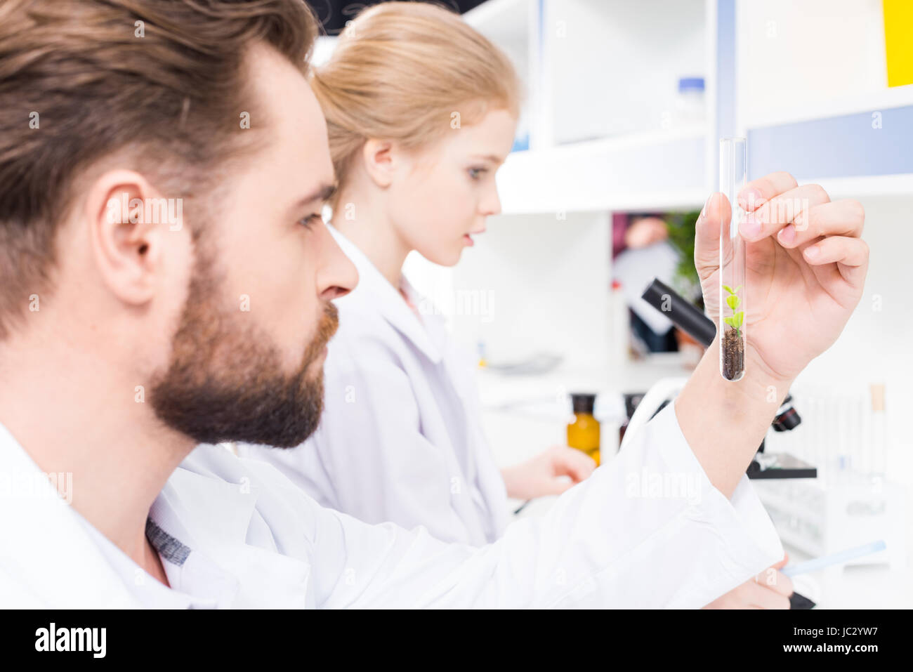 Side view of teacher and student scientists working together in ...