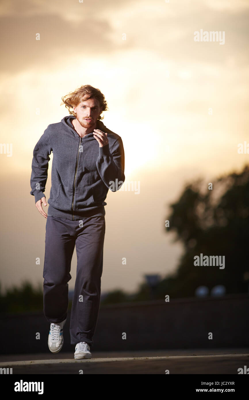 Portrait of young sportsman running outside Stock Photo - Alamy