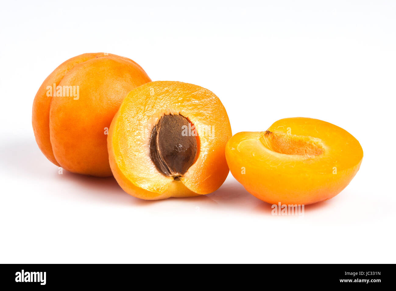 Two ripe fresh apricots isolated on white background. One cut in half ...