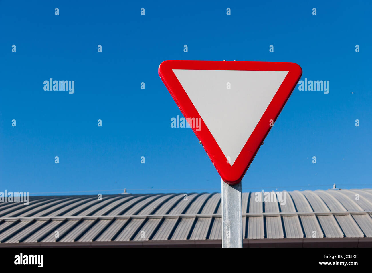 Yield - Give a way sign against blue sky Stock Photo - Alamy
