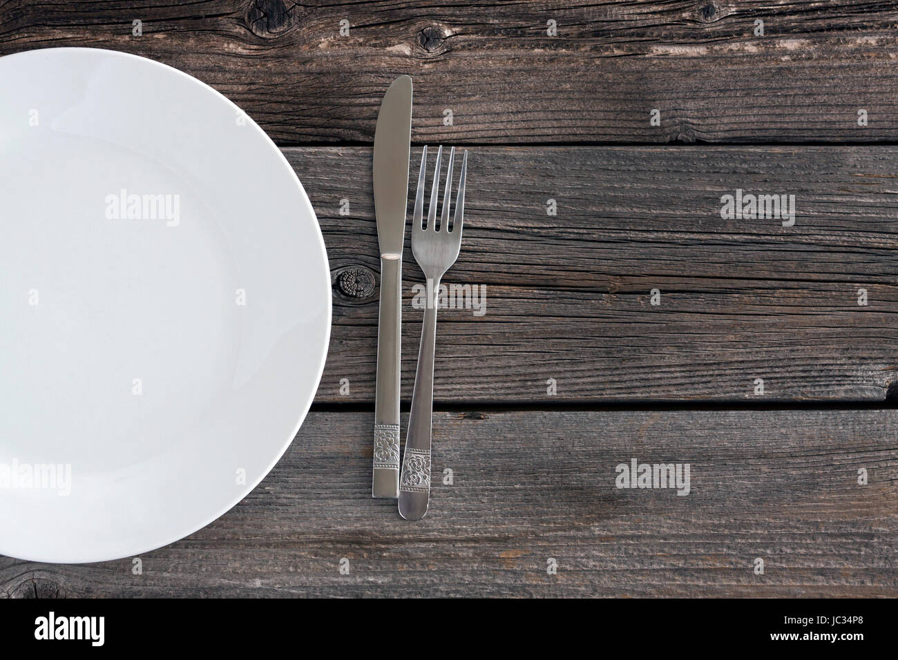 Leerer Teller mit Besteck auf Holztisch Stock Photo - Alamy