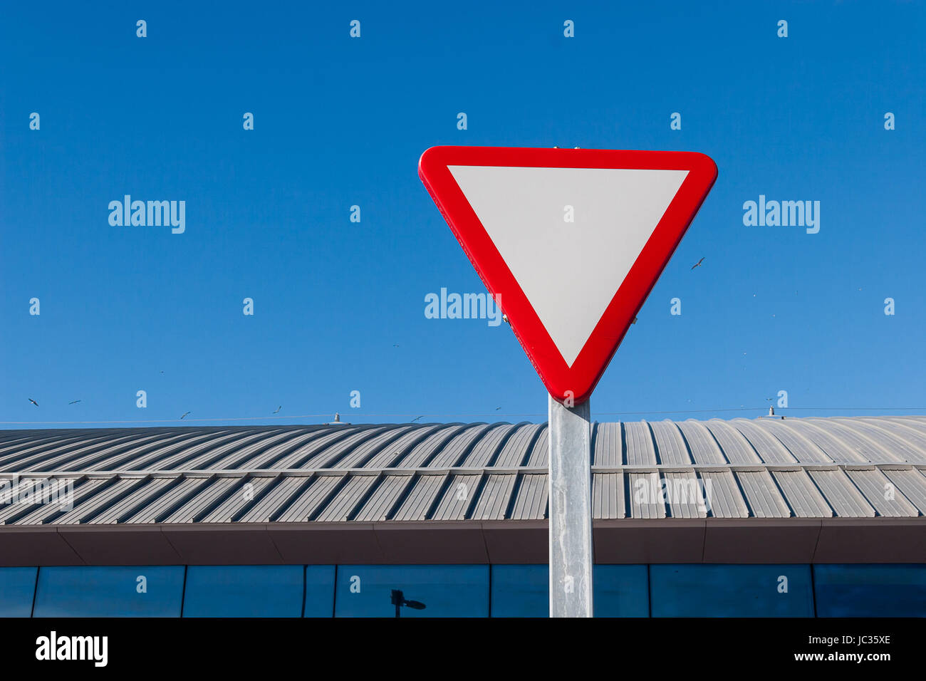 Yield - Give a way sign against blue sky Stock Photo - Alamy