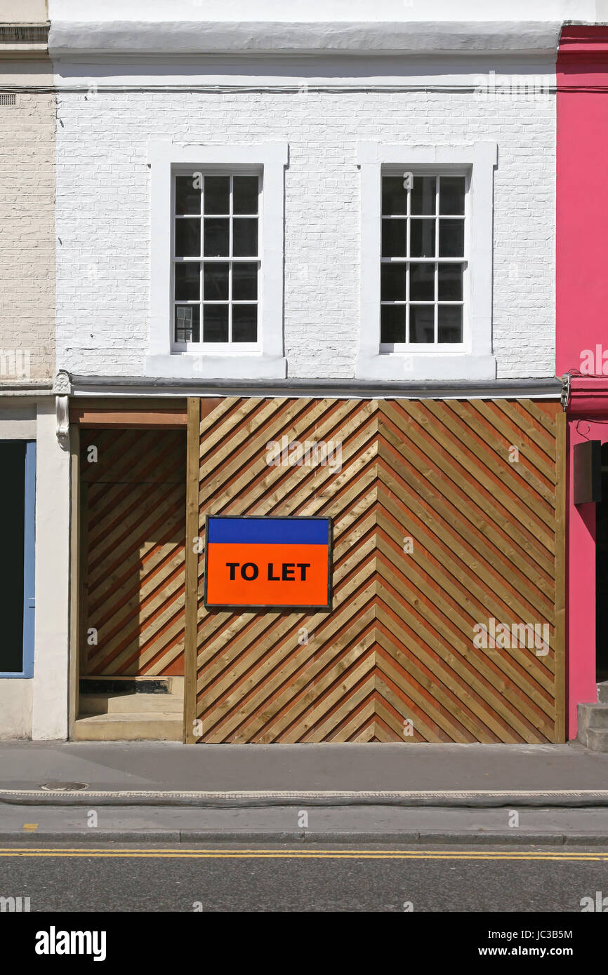 Empty shop with to let sign and wooden barrier Stock Photo - Alamy