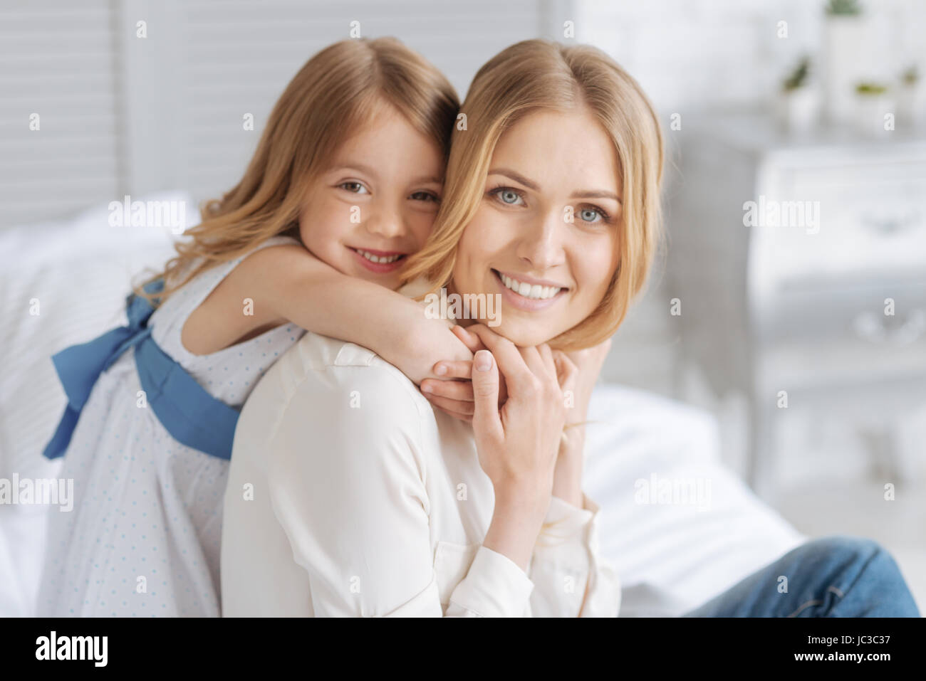 Cute little daughter hugging her mother Stock Photo - Alamy