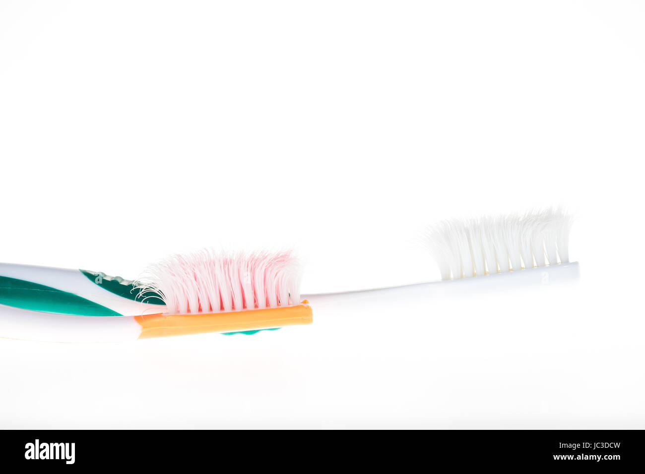 Two Color worn toothbrush on white background Stock Photo - Alamy