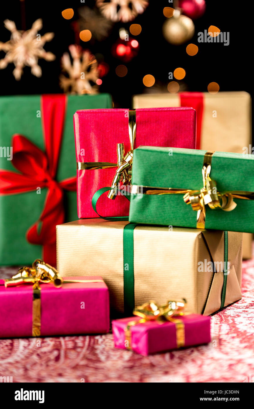 Stack of plain presents in red, green and gold placed on a festive ...