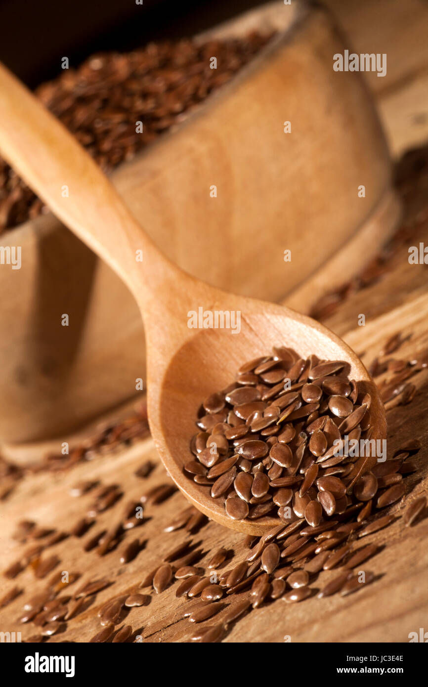 Linseed. Bowl and spoon with linseeds on wooden background Stock Photo - Alamy