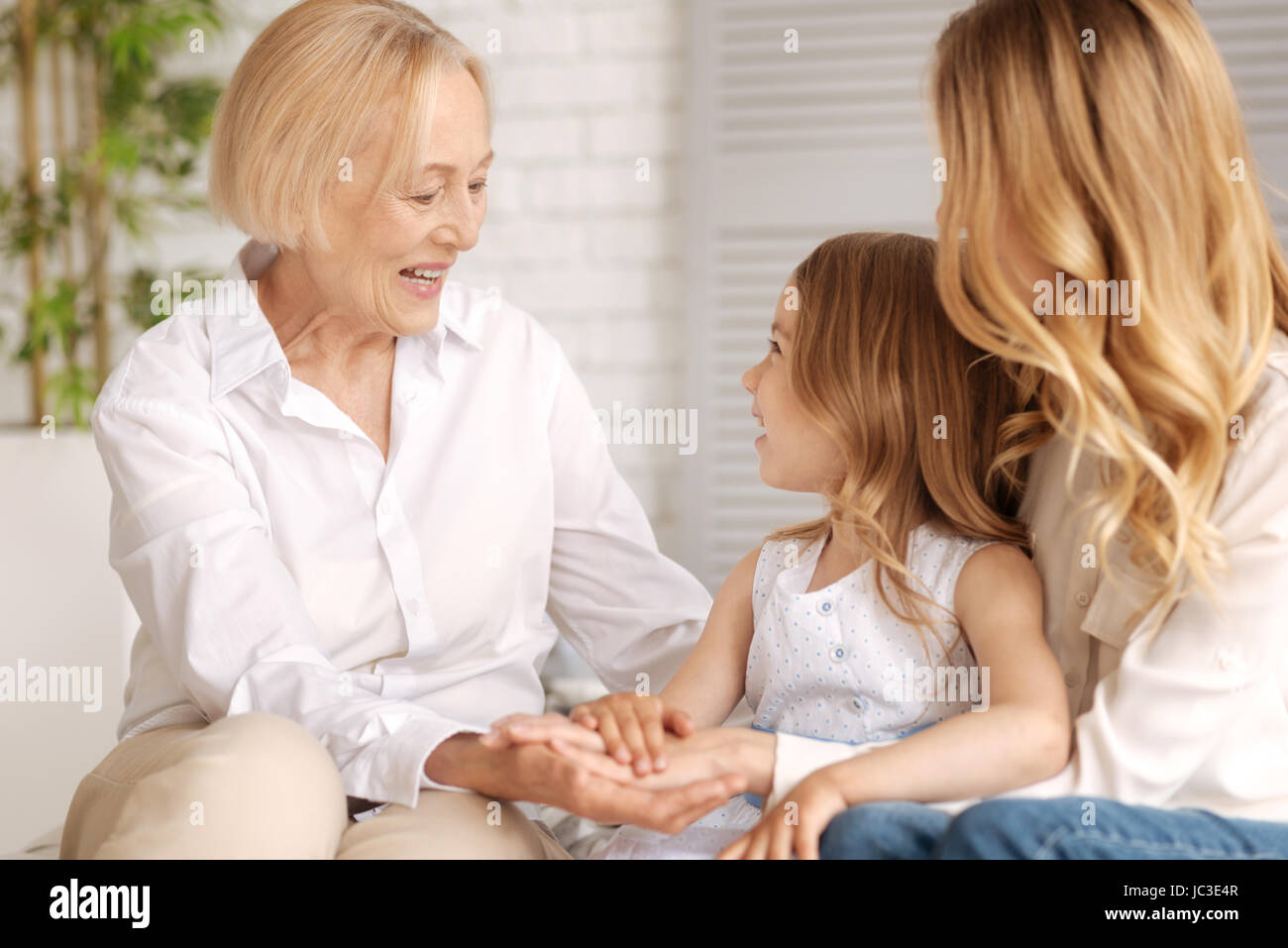 Three generations of women holding hands together Stock Photo - Alamy